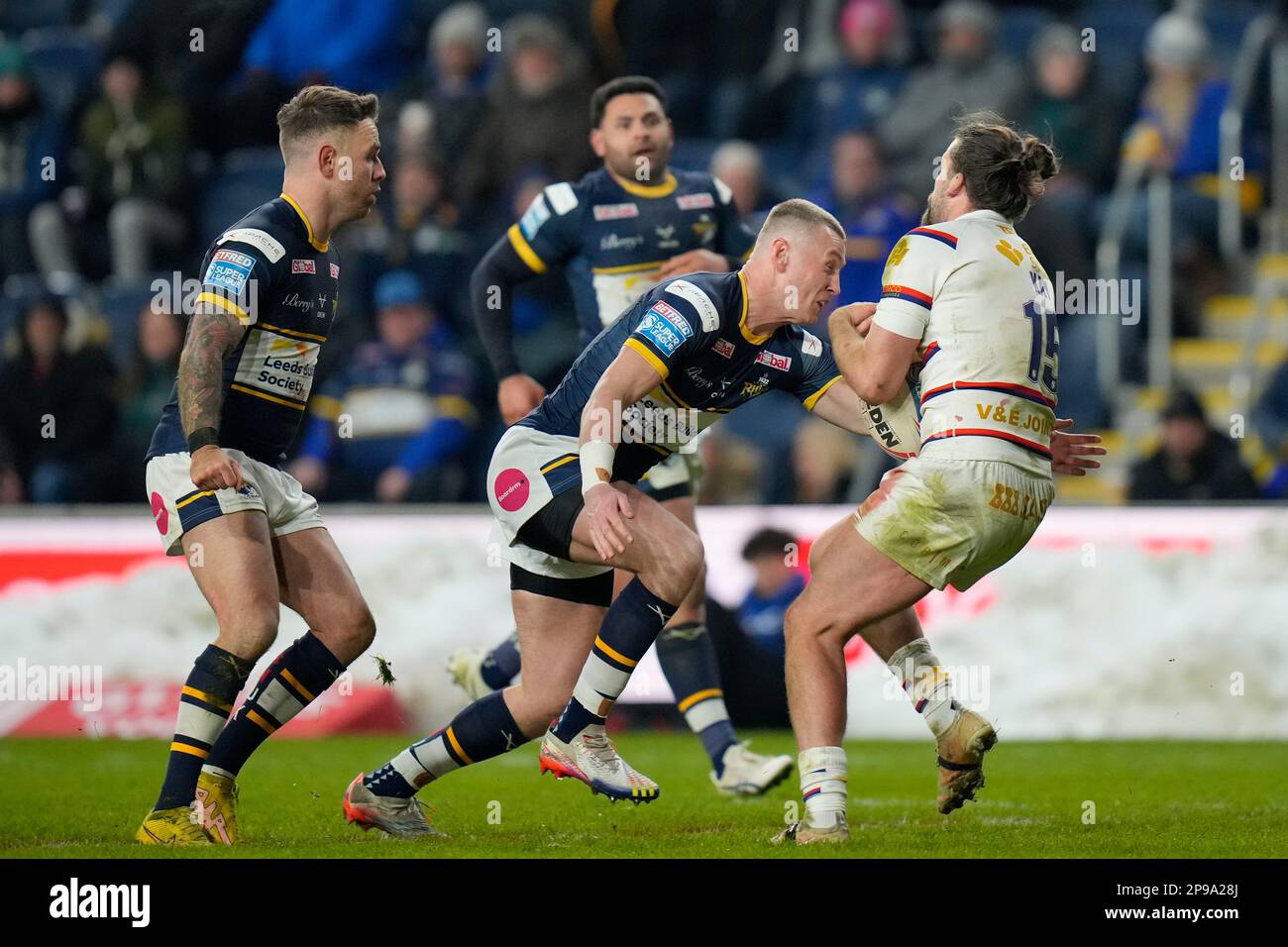 Harry Newman #3 of Leeds Rhinos lines up a tackle on Liam Kay #15 of ...