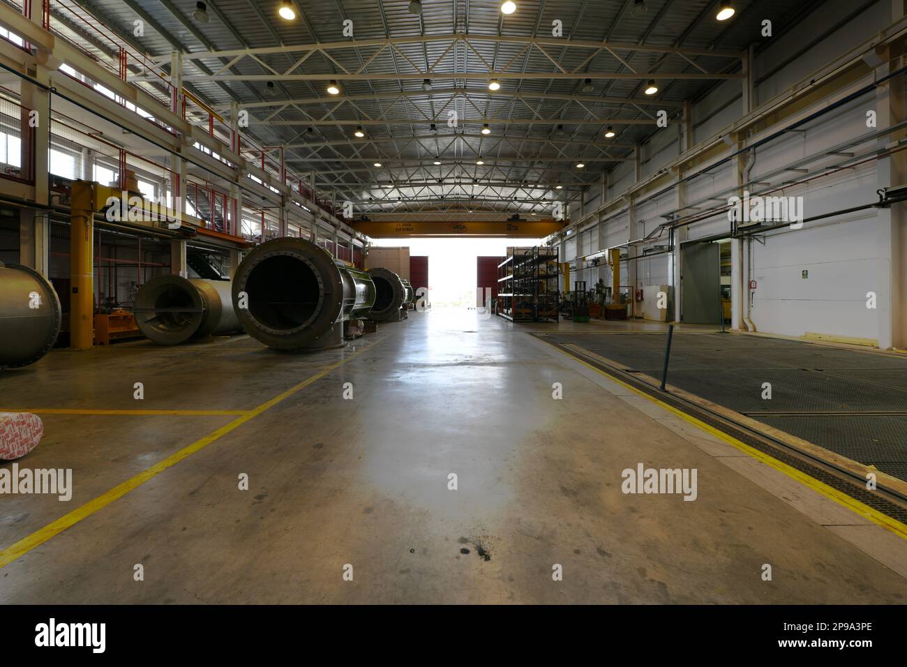 Warehouse of a factory with heavy cranes on roof rails, large ...
