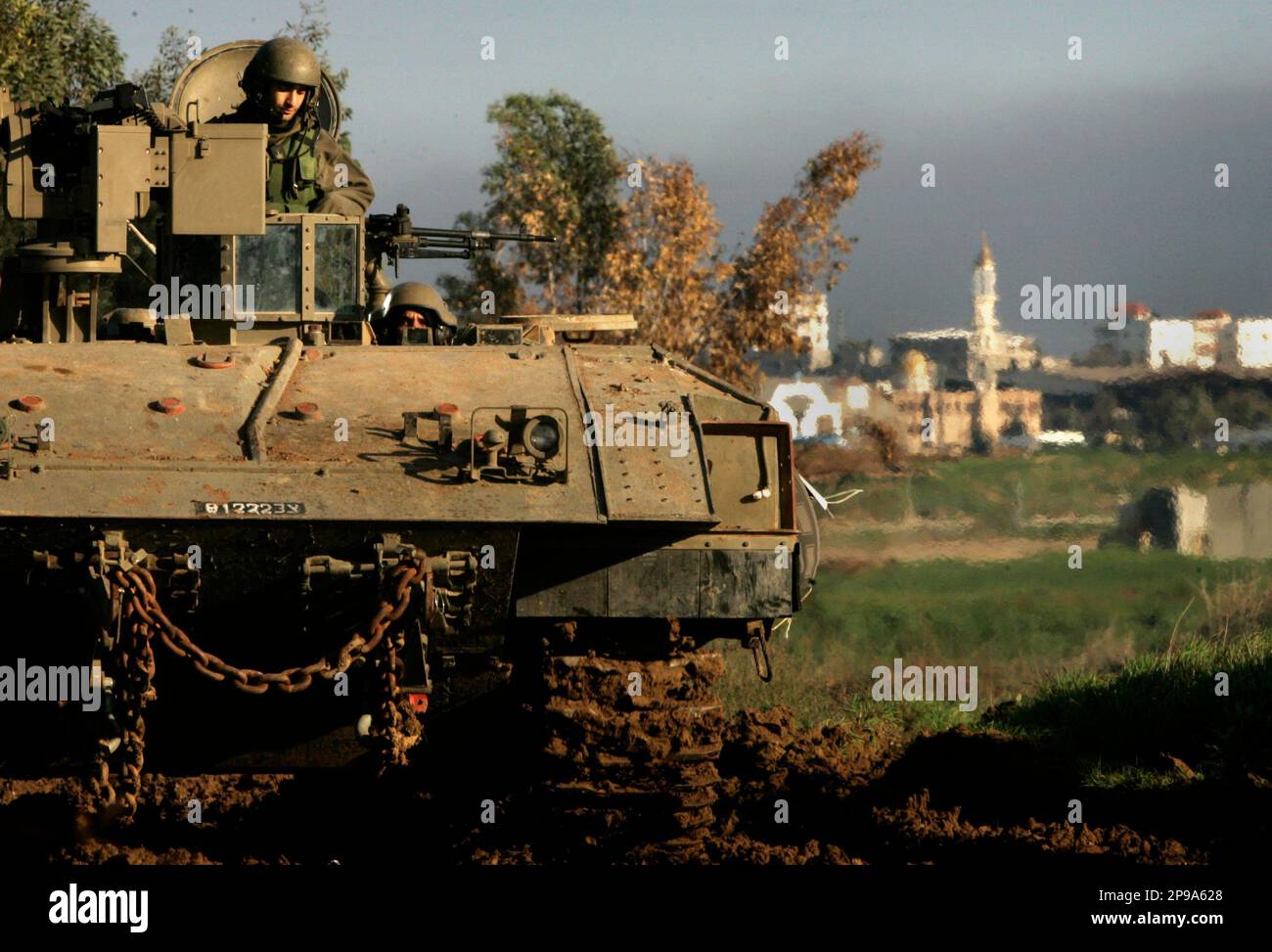 An Israeli armoured vehicle takes up a position on the border before ...