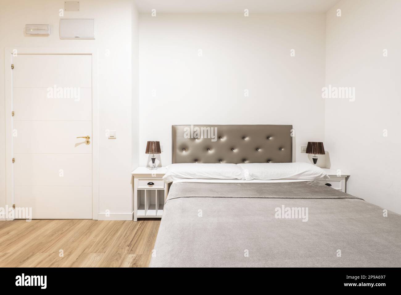 Bedroom with a double bed attached to a wall with twin white wooden ...