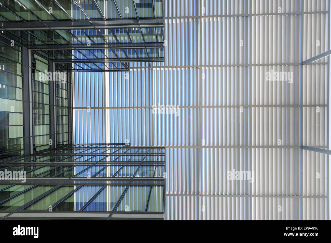 office building with a metal and glass facade, trees and hedges and ...