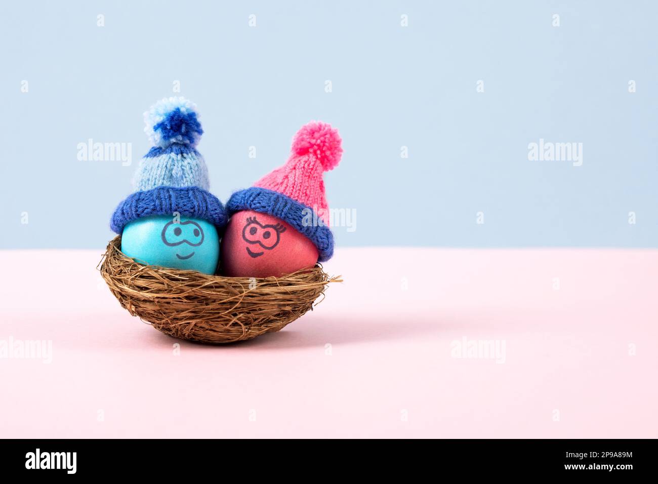 Two Easter eggs with funny faces and crocheted hats in a decorative ...