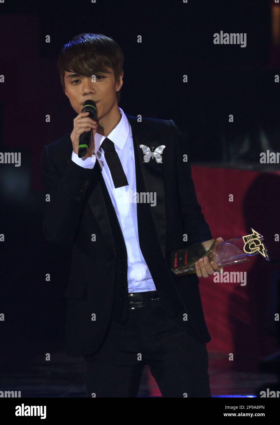 Mainland China singer Hins Cheung, holding his trophy, performs after ...