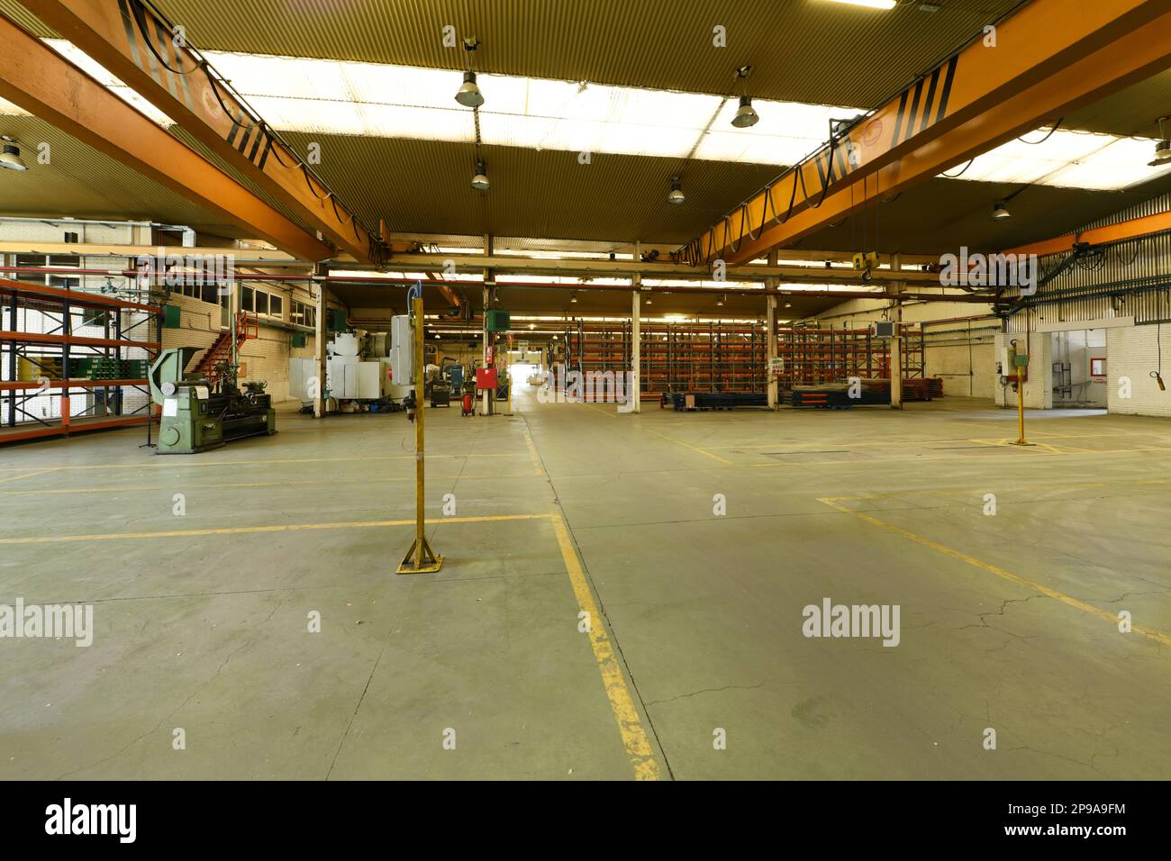 Metal bridge crane of great tonnage in a factory with a storage area ...