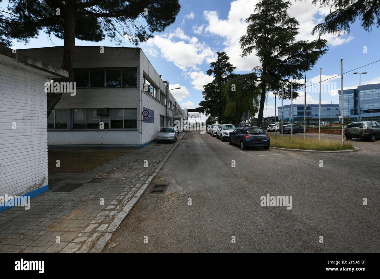 Exterior facade of a factory warehouse with parking and gardens with ...