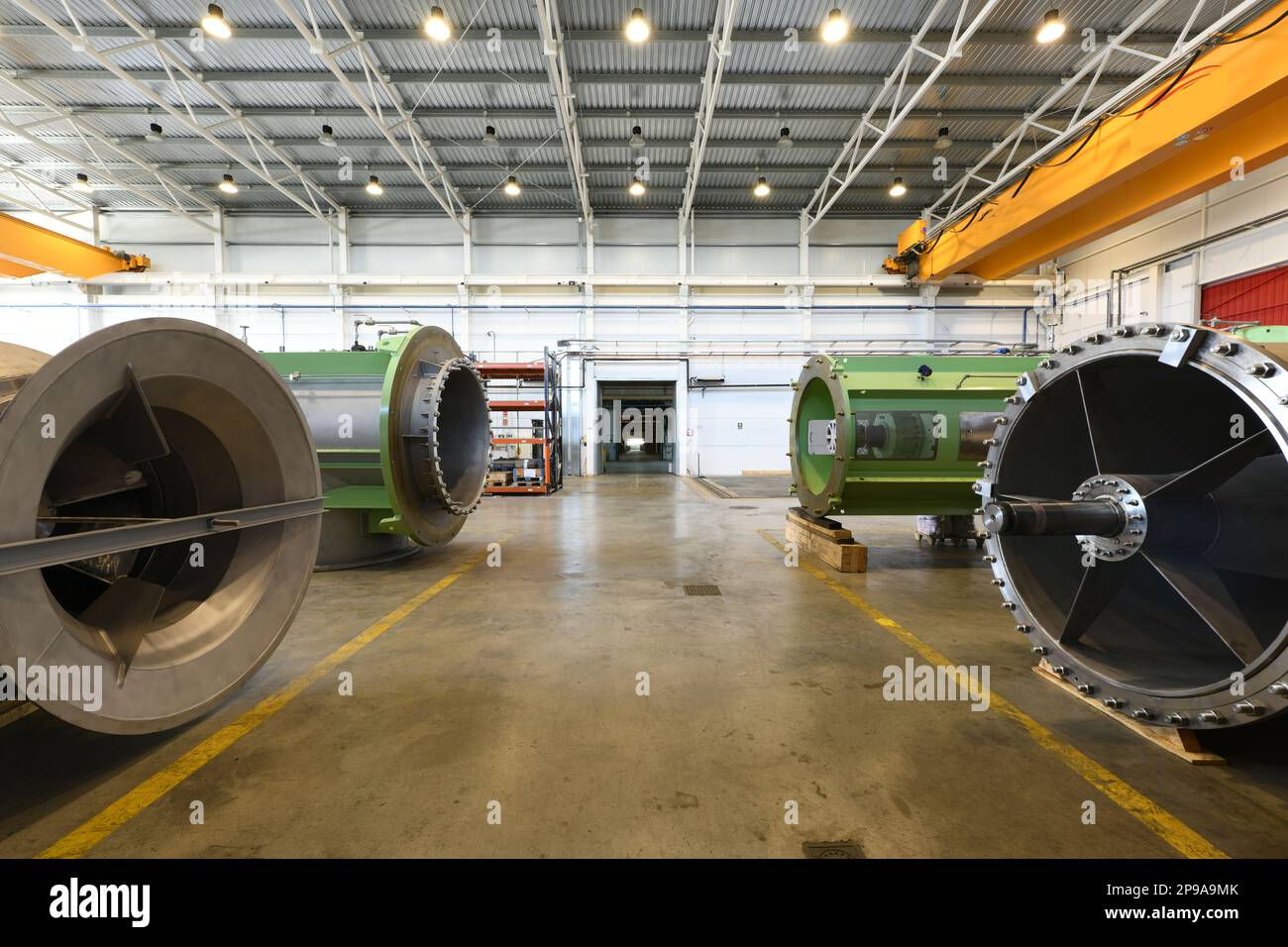 Warehouse of a factory with heavy cranes on roof rails, large ...