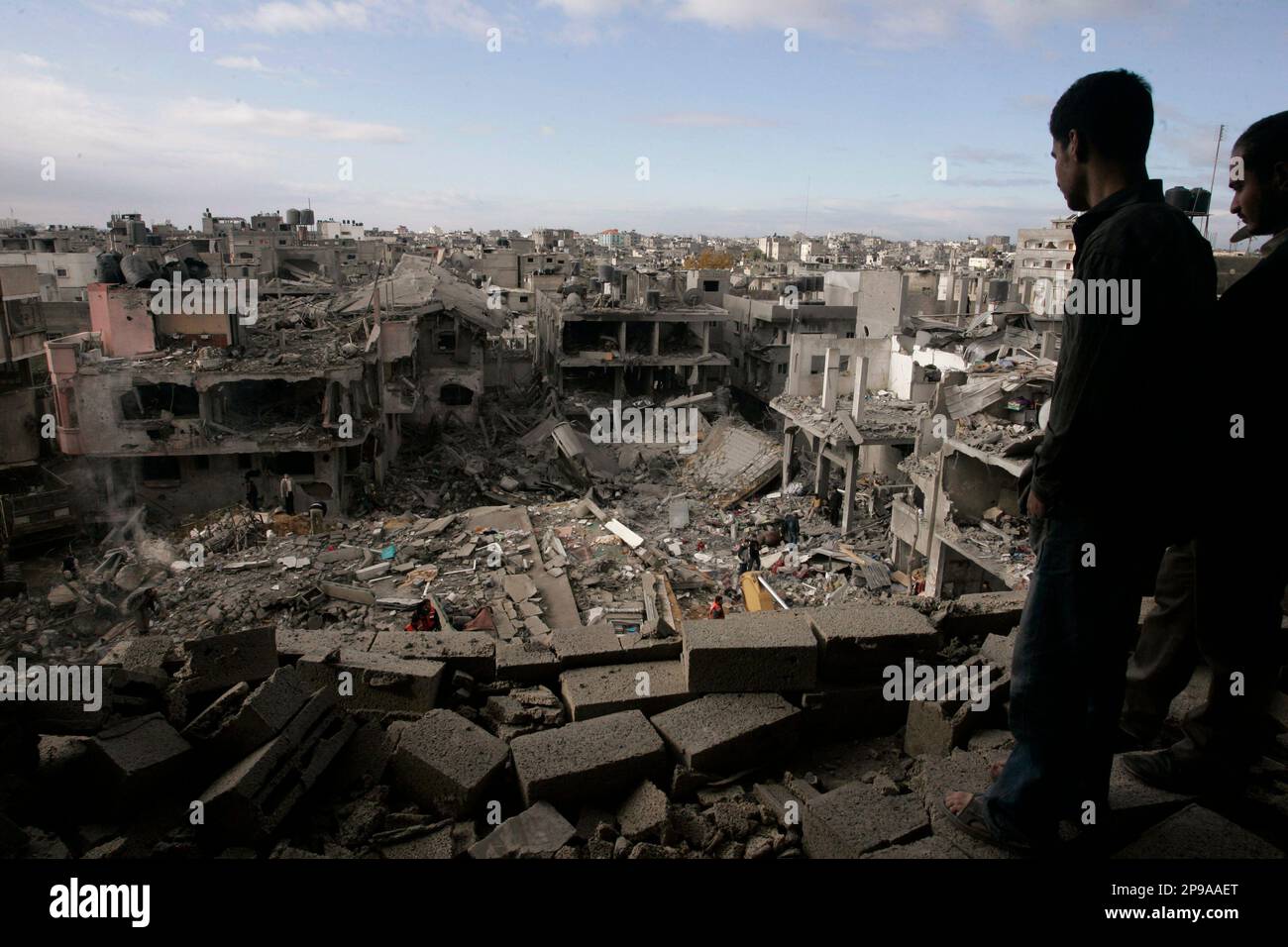 Palestinians look down on the rubble of the destroyed house of senior ...