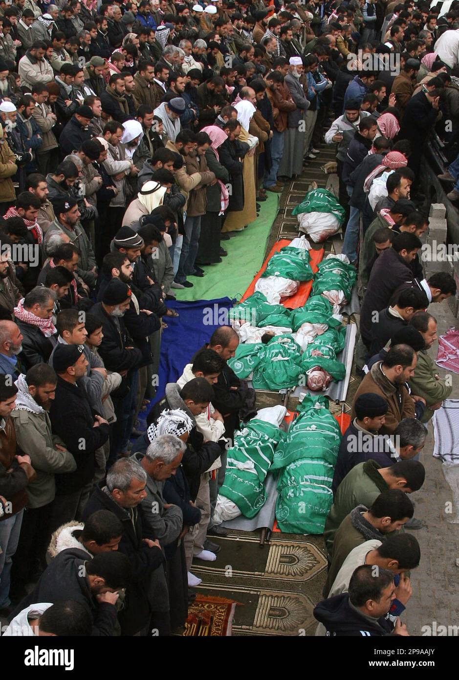 Palestinians pray over bodies during the funeral of Hamas leader Nizar ...