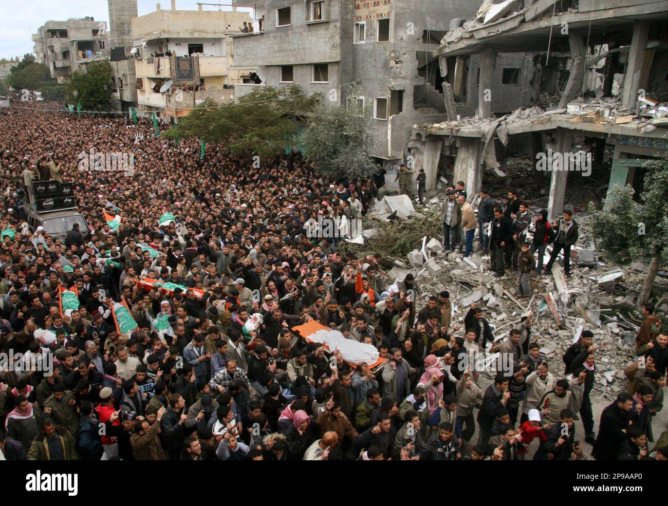 Palestinians carry fourteen bodies during the funeral procession for ...