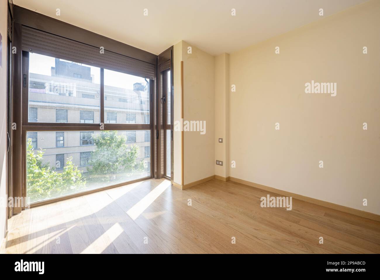 Empty living room with a large brown anodized aluminum window with ...