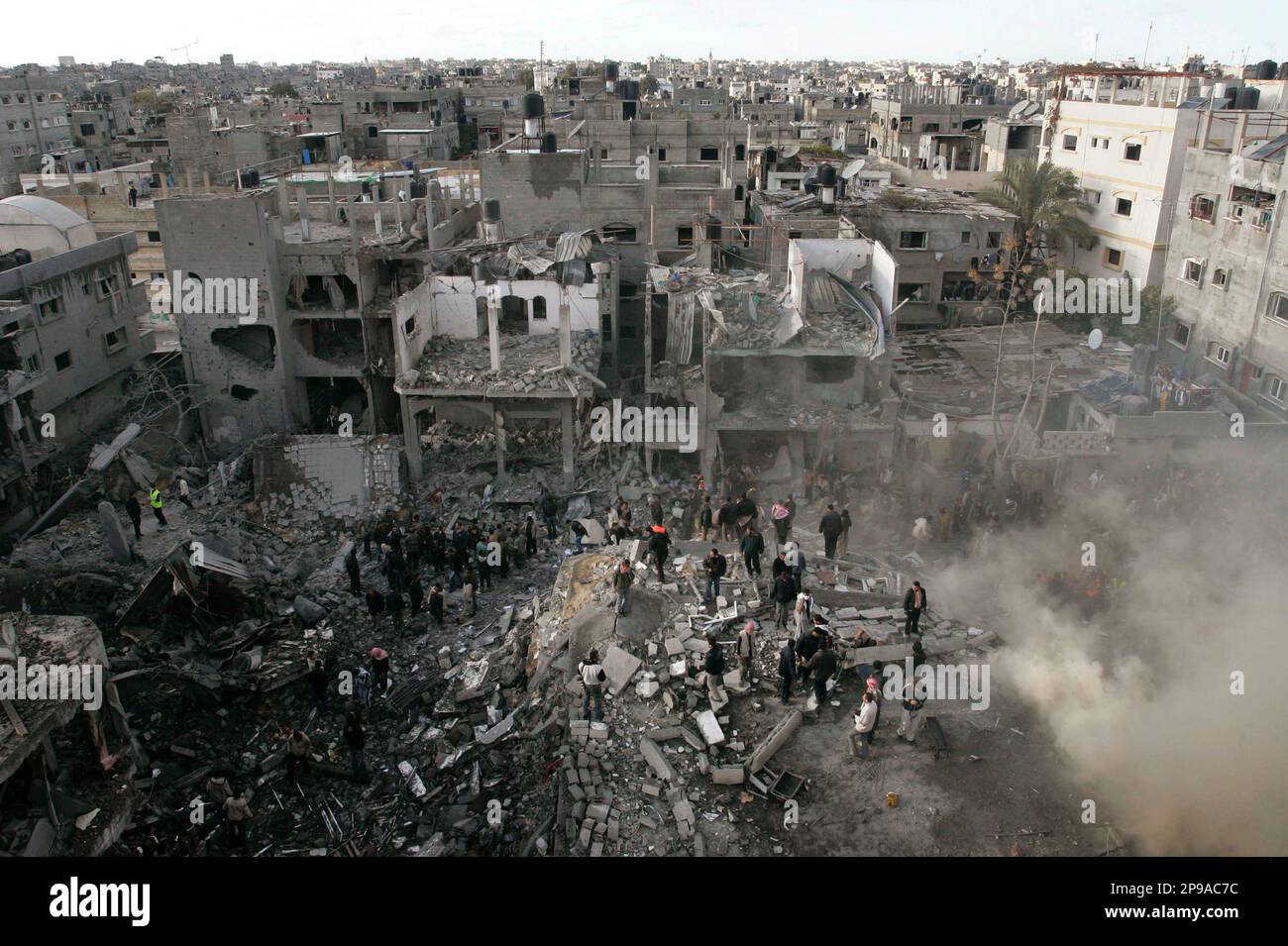 Palestinian firefighters work at the scene of an Israeli air strike on ...