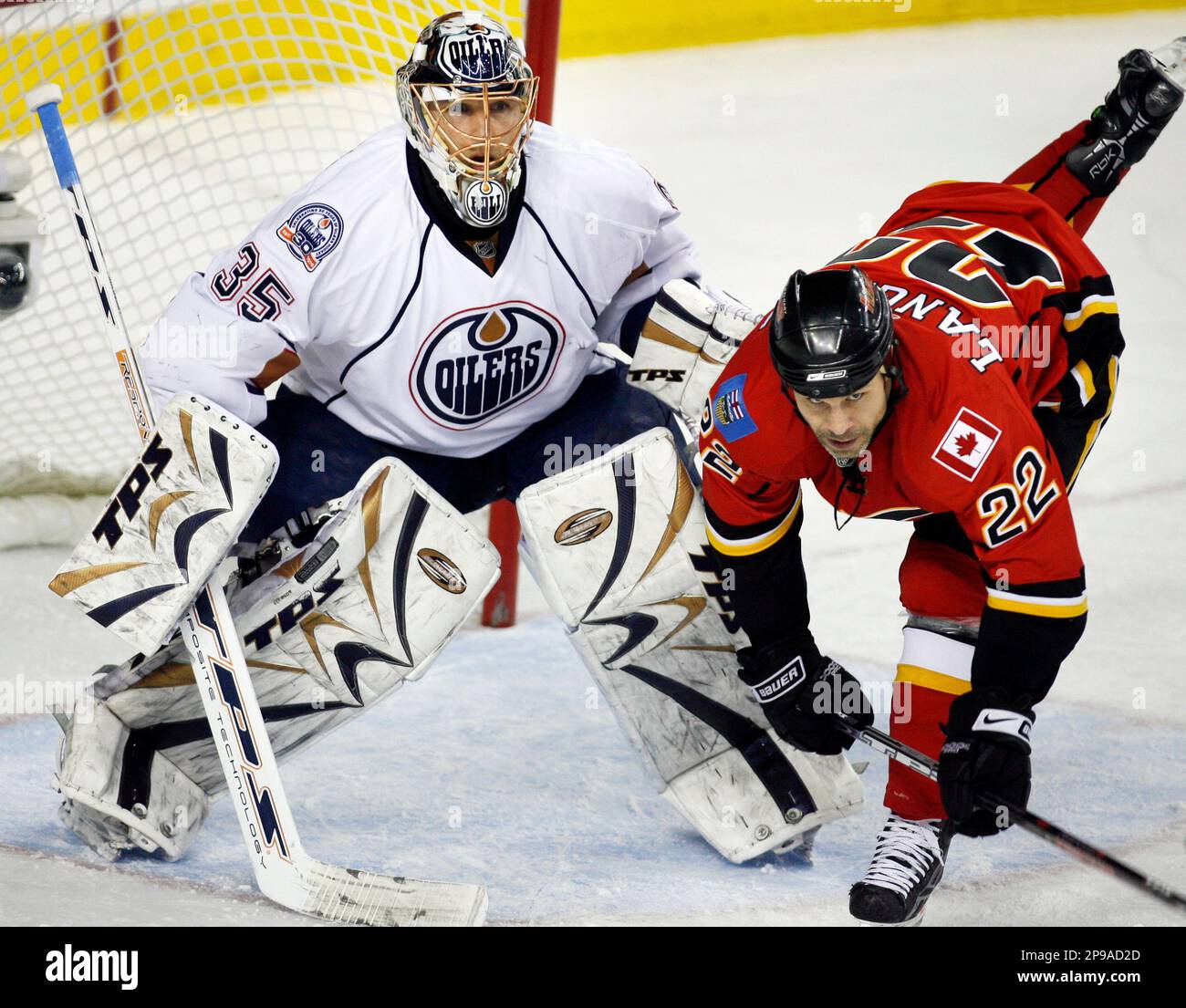 Edmonton Oilers goalie Dwayne Roloson, left, follows the puck as ...