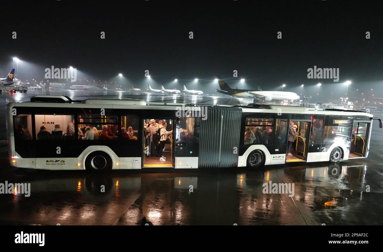 Shuttle-Bus holt Flugpasagiere an einem Aussenparkplatz, im Hitergrund ...