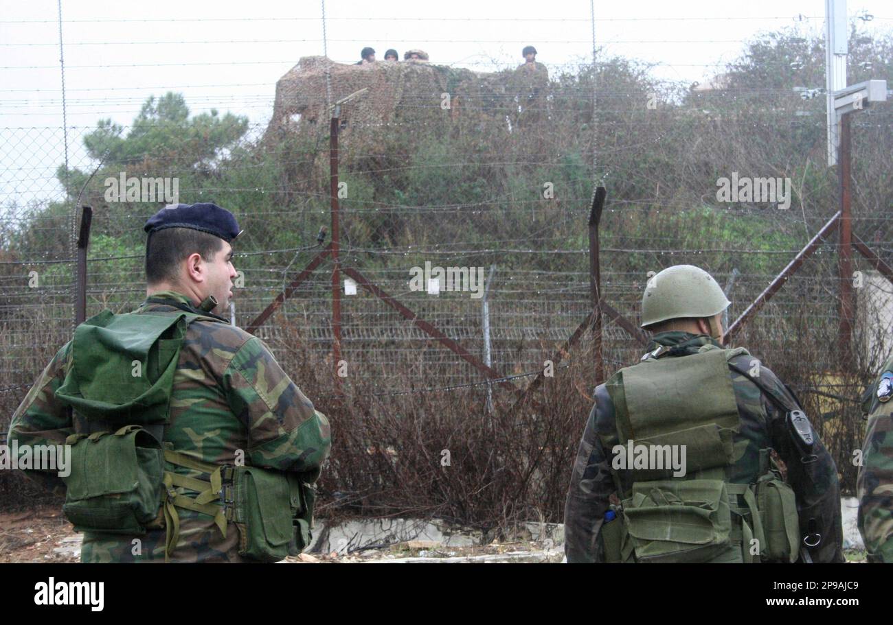 Lebanese, front, and Israeli soldiers, background, are seen patrolling ...