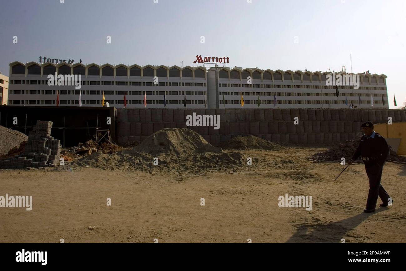A Pakistani police officer walks past under construction giant ...