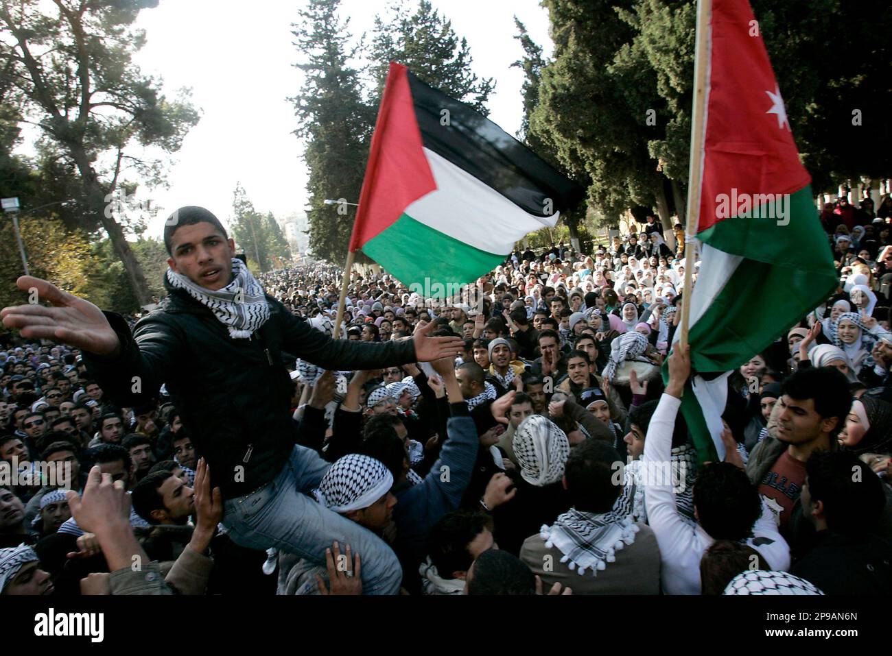 Jordanian students holds Jordanian and Palestinian flags demonstrate ...