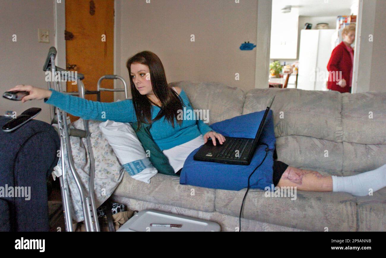Michelle Saye uses her computer on her sofa in her Seattle area home ...