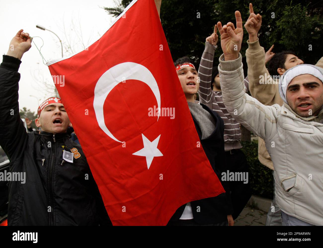 Turkish men, holding a national flag, chant nationalist slogans during ...