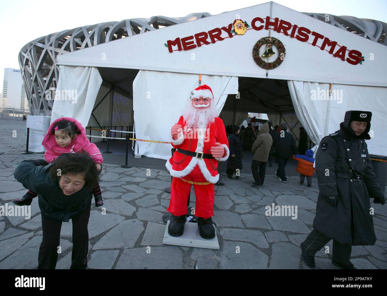 A mechanic Santa Claus dances to welcome visitors at a security ...