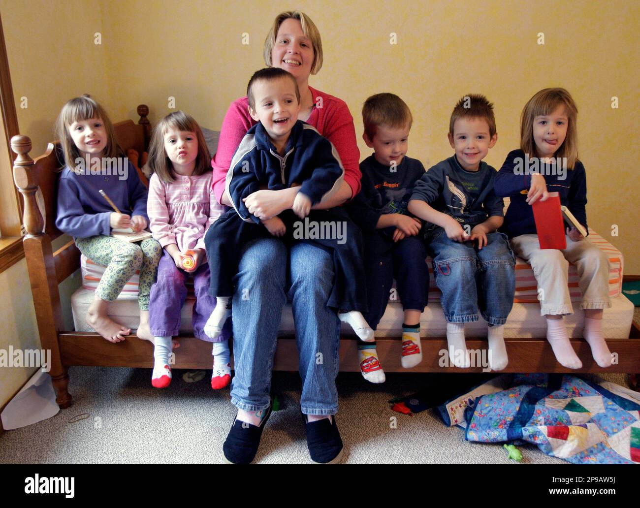 Jennifer Hanselman sits on a bed with her 4-year-old sextuplets, from ...