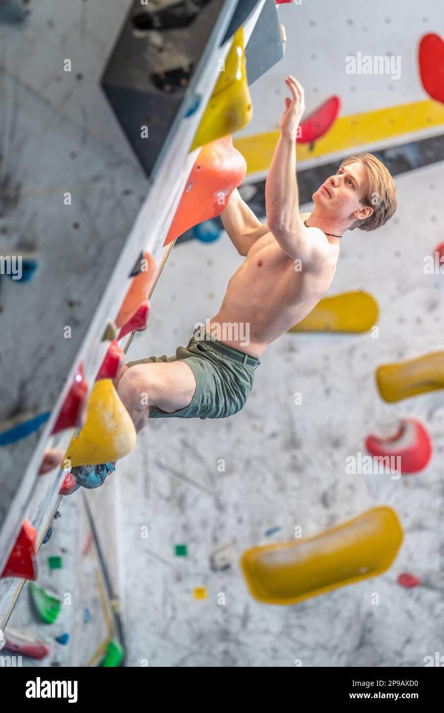 young man on a boulder climbing wall Stock Photo - Alamy
