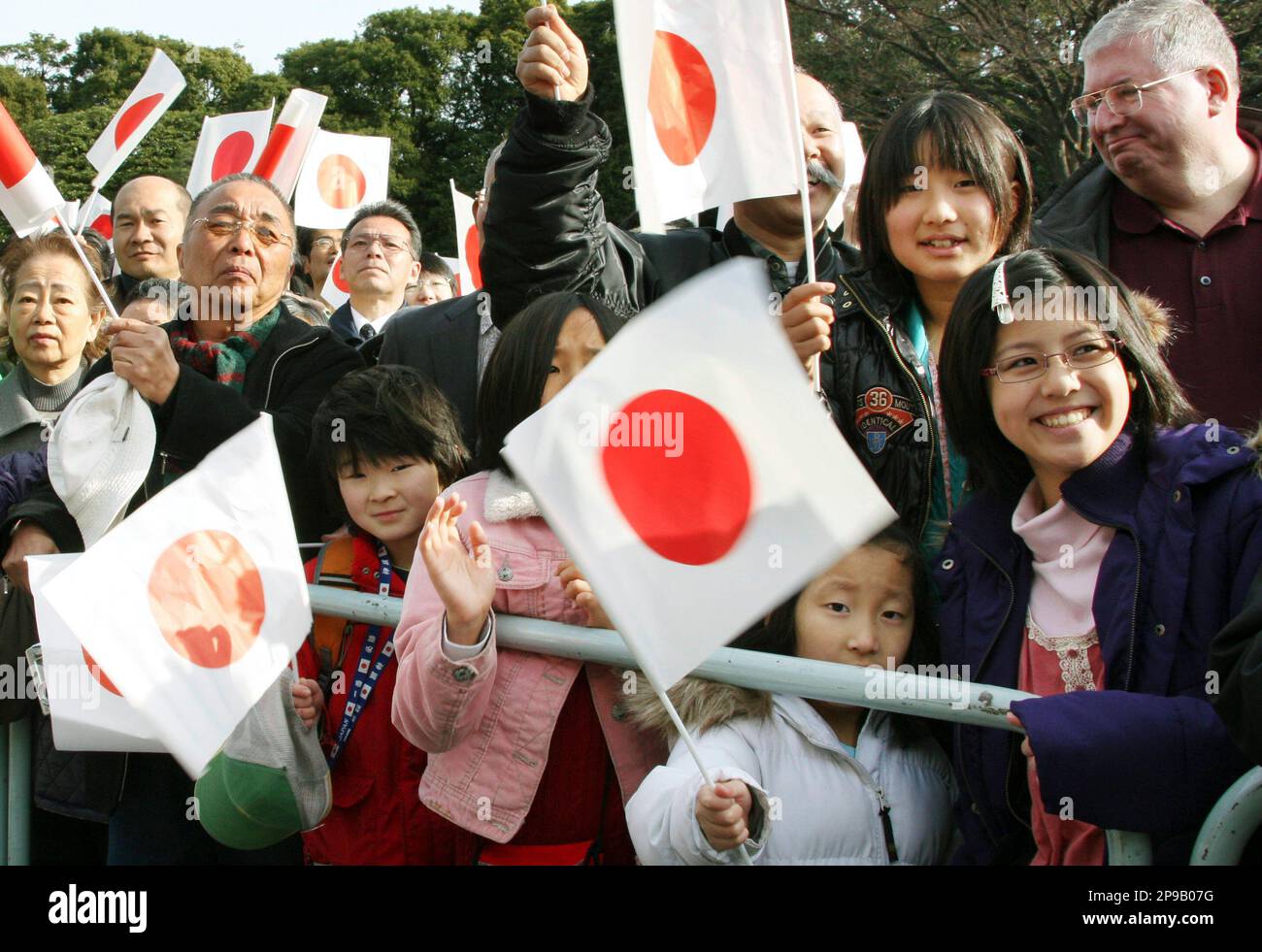 Well-wishers wave Japanese flags as Japan's Emperor Akihito makes a ...