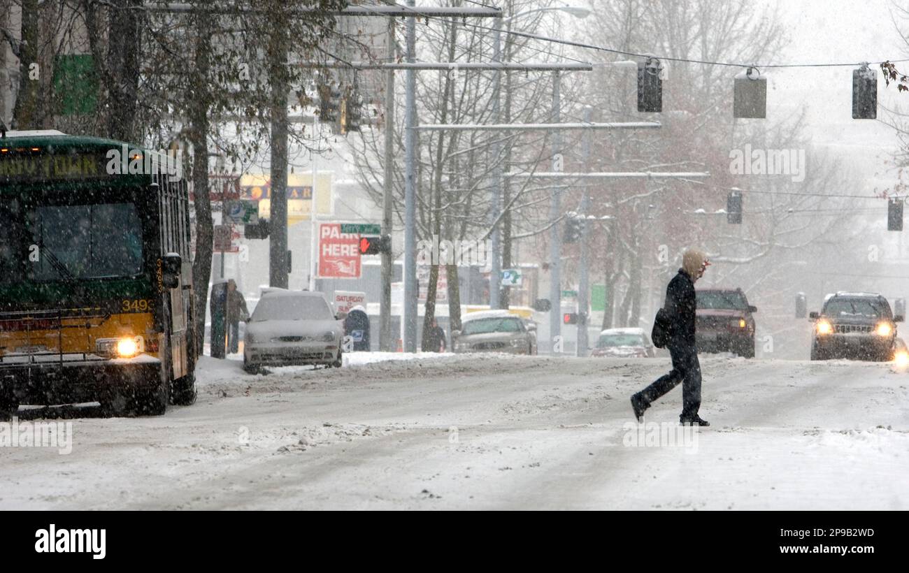 A pedestrian crosses snow covered Stewart Street in downtown Seattle as ...