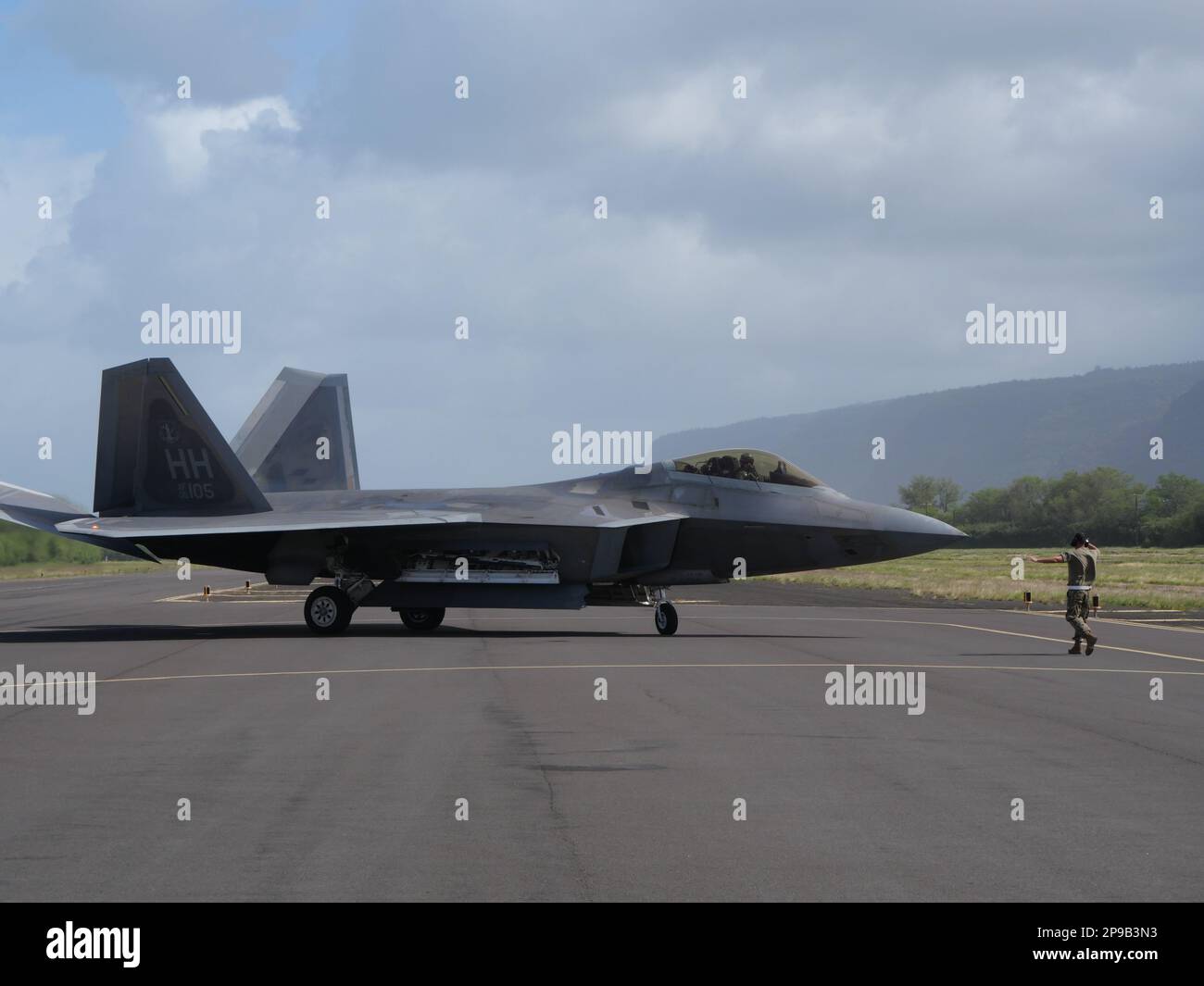 An F-22 Raptor, assigned to the 199th Fighter Squadron, is marshaled by ...