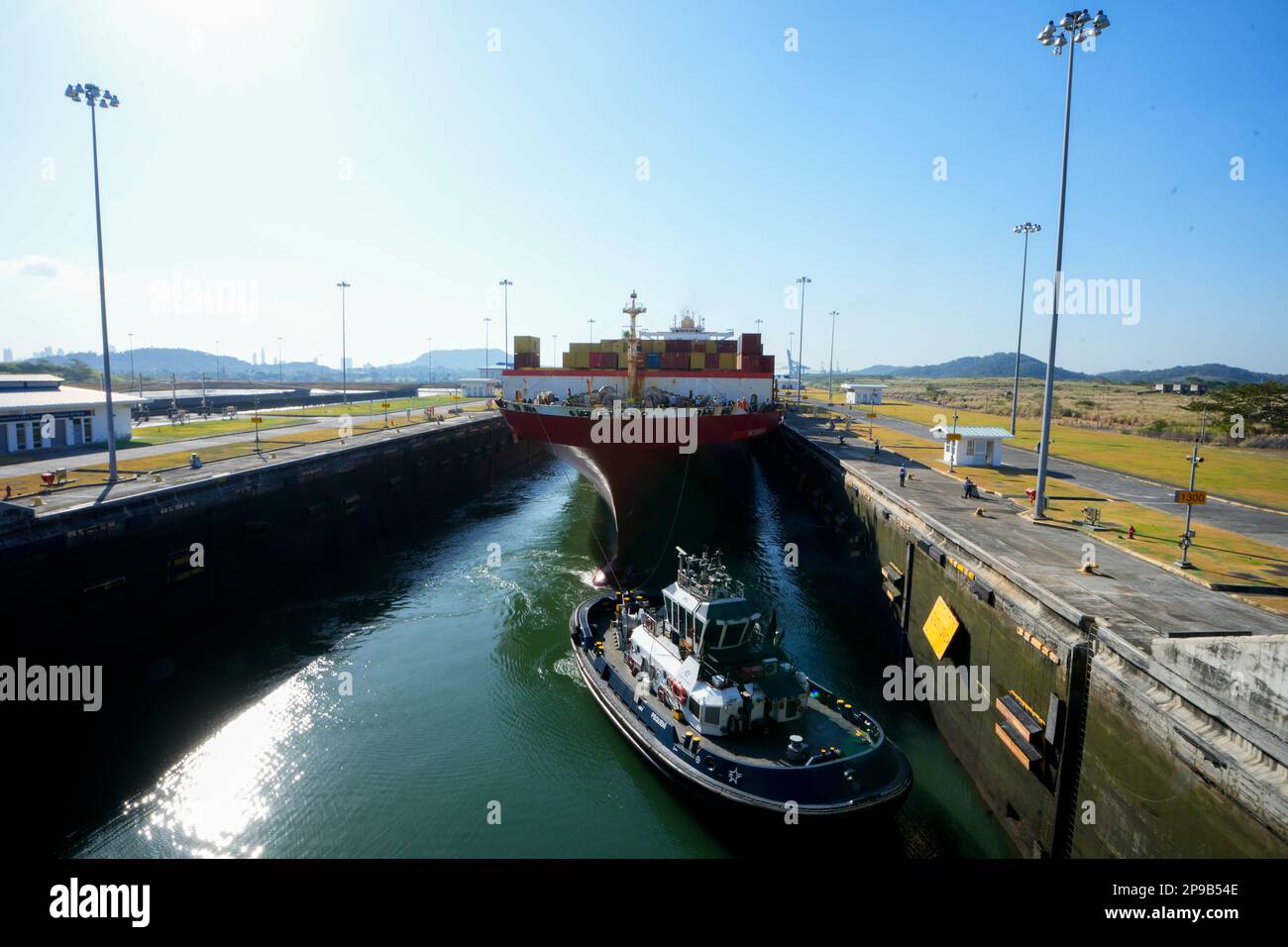 A cargo ship is guided by a tugboat through the Panama Canal's Cocoli ...