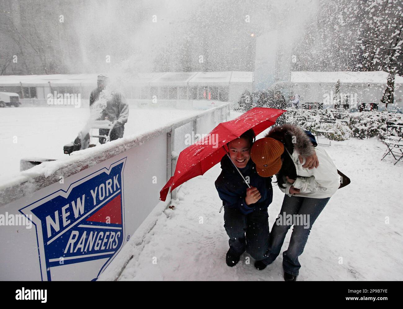 New York residents Freedman Zheng, center, and Patti Fuertez duck under ...