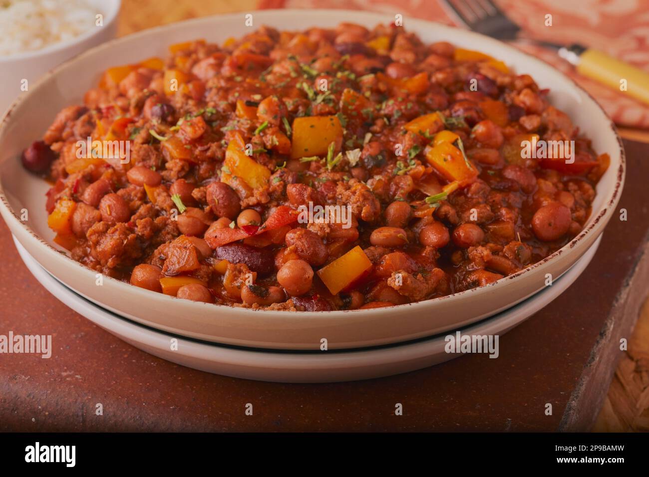 Mexican chilli on a large plate and garnished with herbs Stock Photo ...