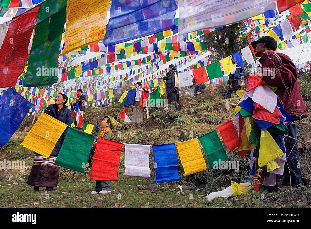 People hanging Tibetan prayer flags in Lhagyal Ri, near Tsuglagkhang ...