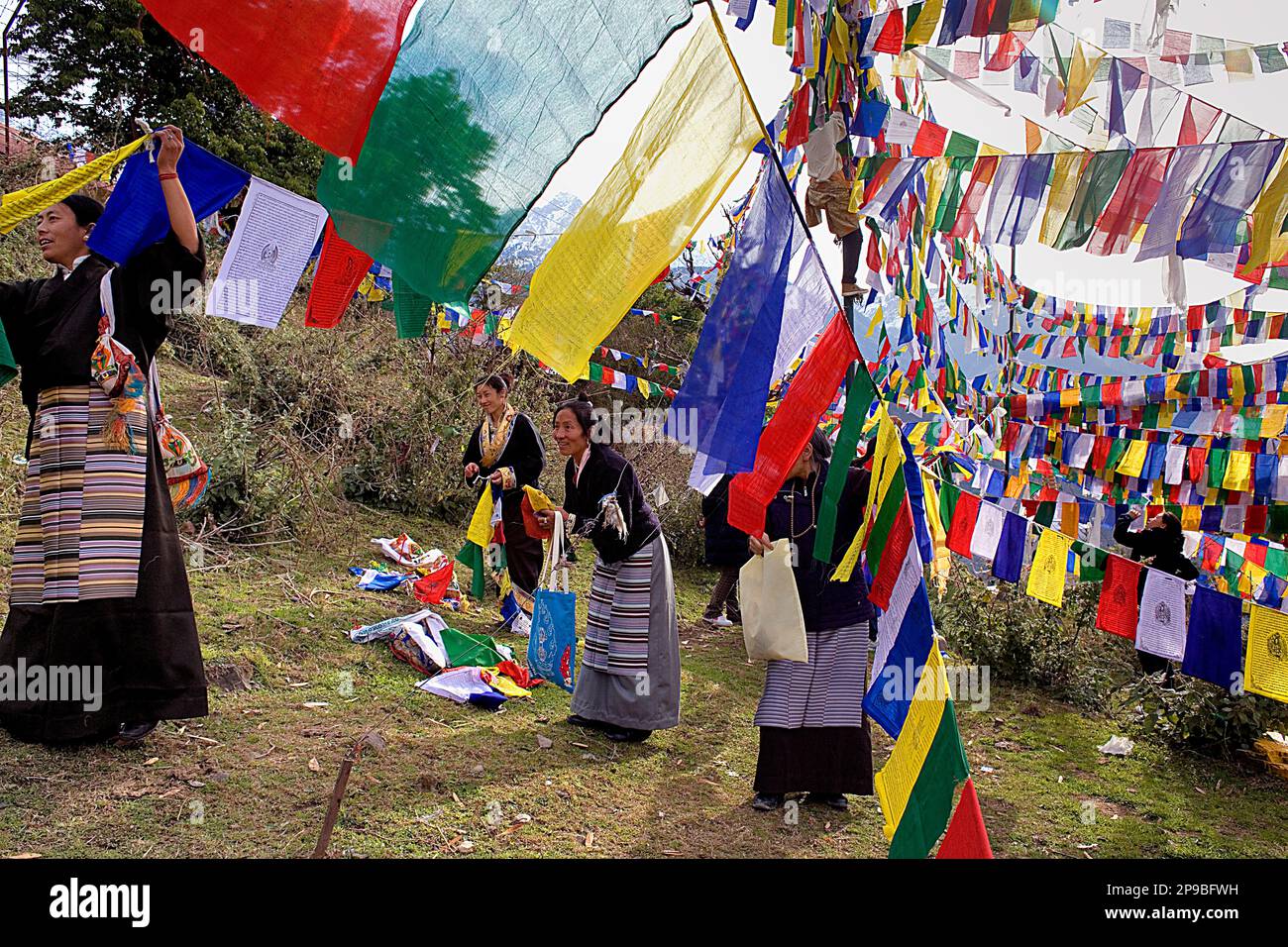 People hanging Tibetan prayer flags in Lhagyal Ri, near Tsuglagkhang ...