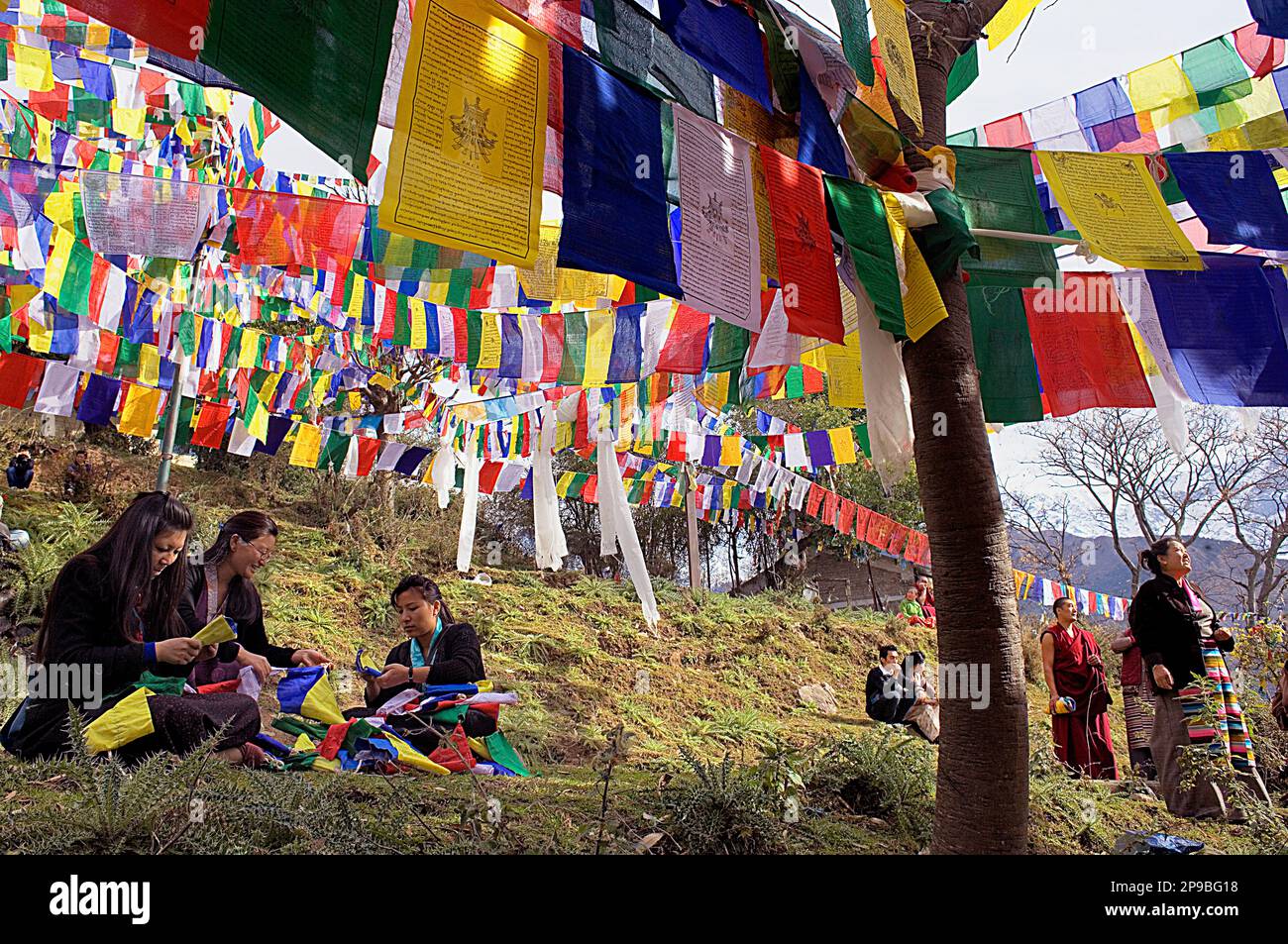 People hanging Tibetan prayer flags in Lhagyal Ri, near Tsuglagkhang ...