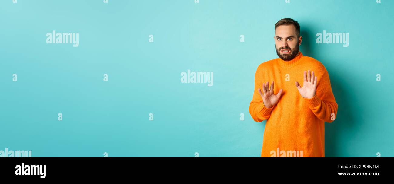 Alarmed guy shaking hands in rejection, declining and stepping away ...