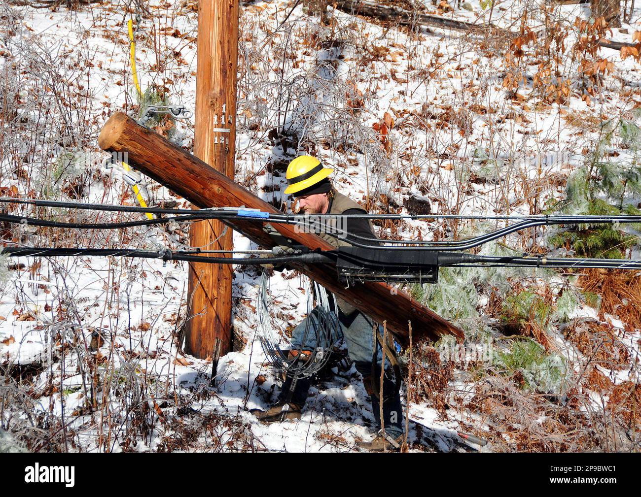 A utility worker fixes a snapped utility pole in Chester, Vt., Friday ...