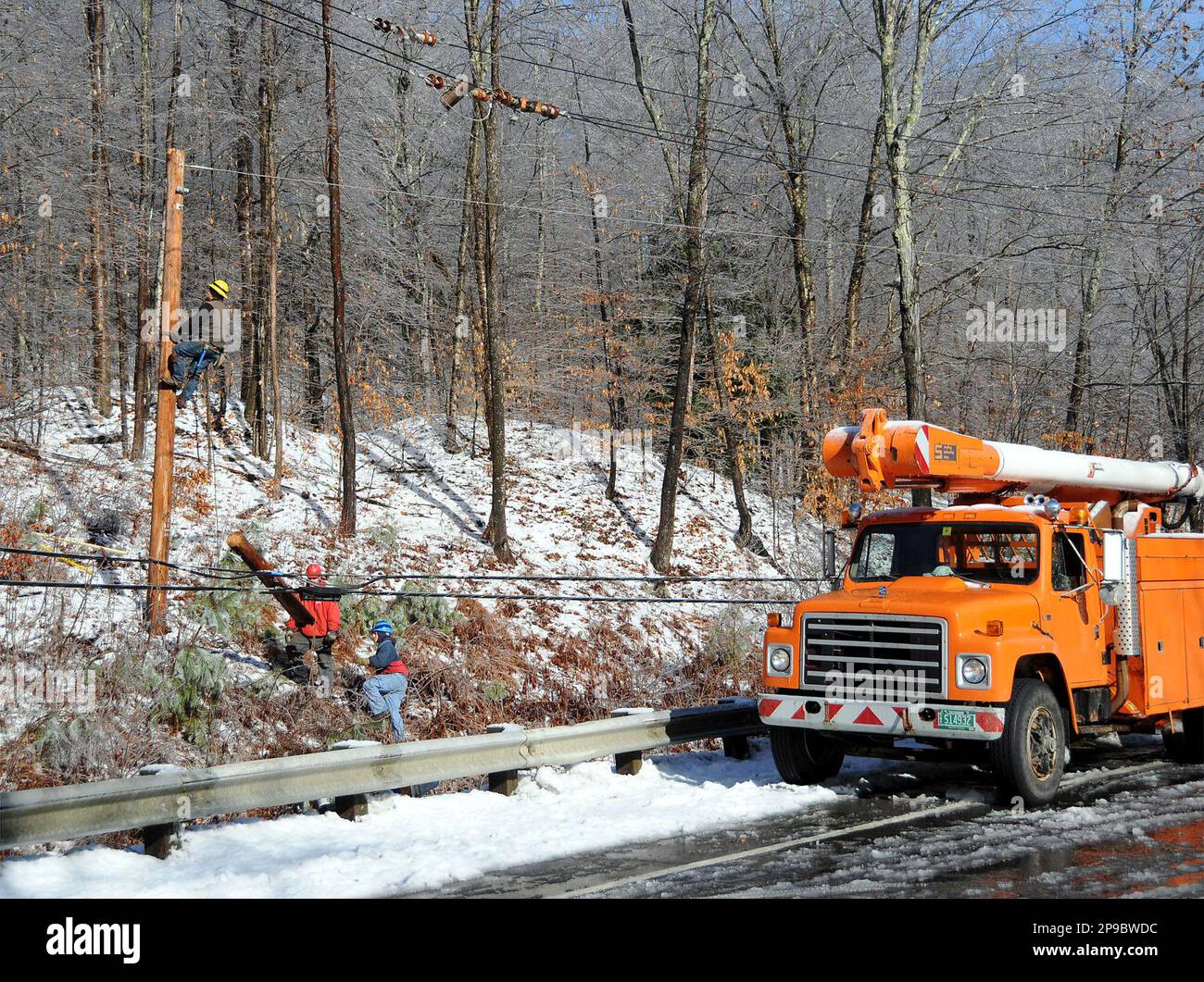 Utility workers work to fix a snapped utility pole in Chester, Vt ...