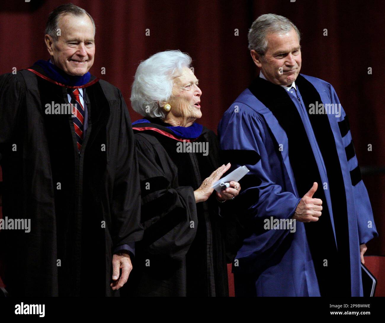 President George W. Bush, right, gestures with a "gigem" sign as he ...