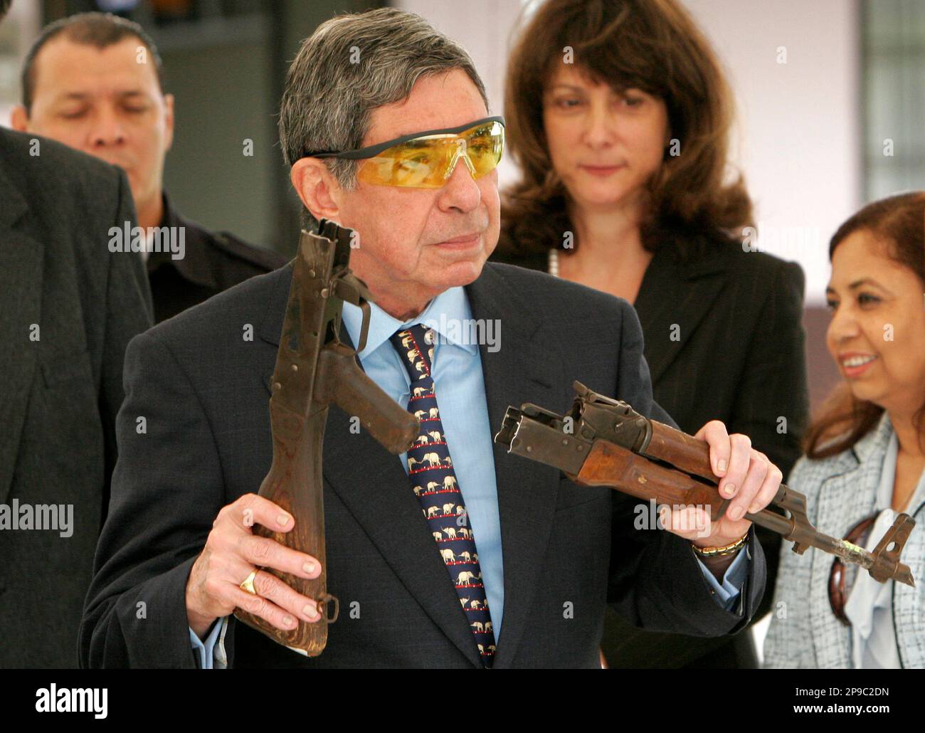 Costa Rica's President Oscar Arias, center, holds up an AK-47 rifle he ...