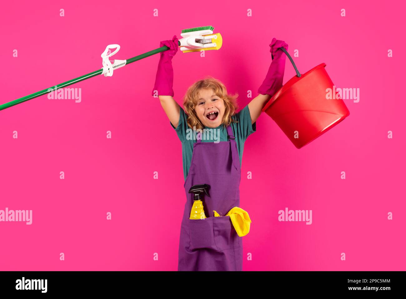 Child doing housework. Studio portrait of child use duster and gloves ...