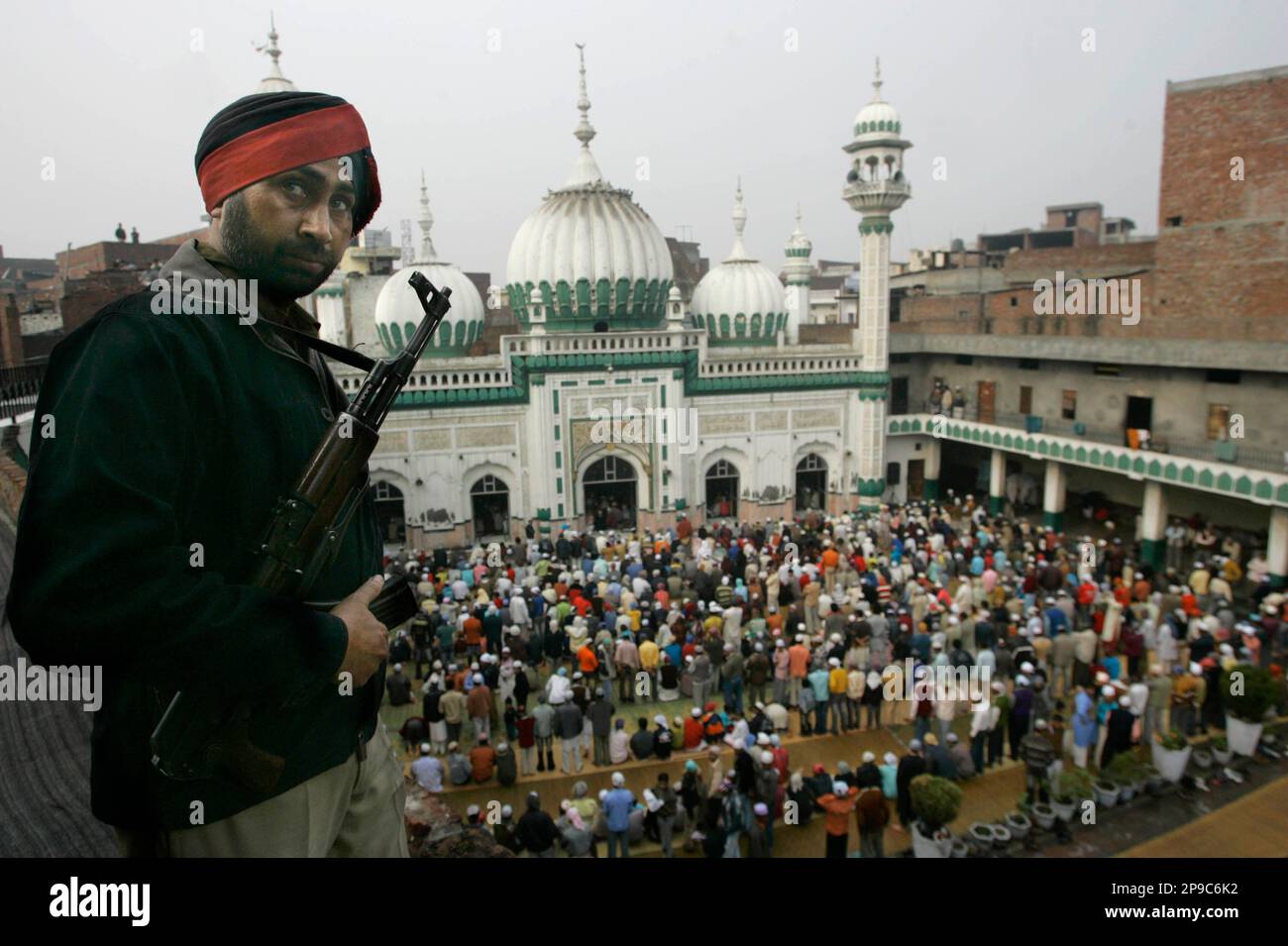 An Indian police officer stands guard as Muslims offer Eid al-Adha ...