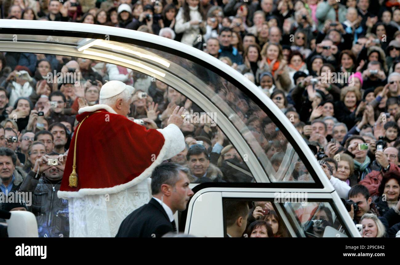 Pope Benedict XVI, with red cape standing on his popemobile, is driven ...