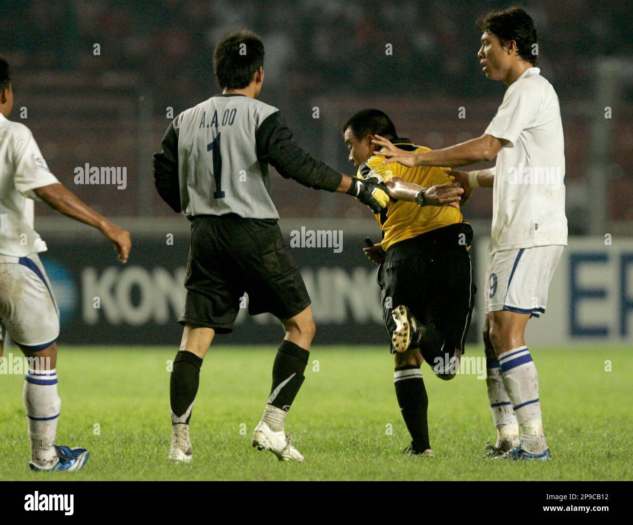 Myanmar's goalkeeper Aung Aung Oo, center, pushes referee Phung Dinh ...