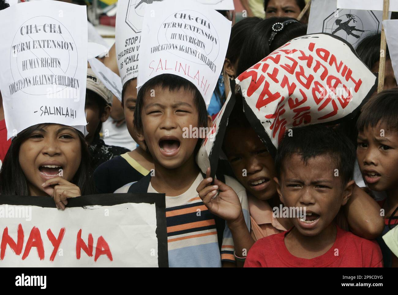 Children wearing improvised headgear shout slogans during a rally near ...