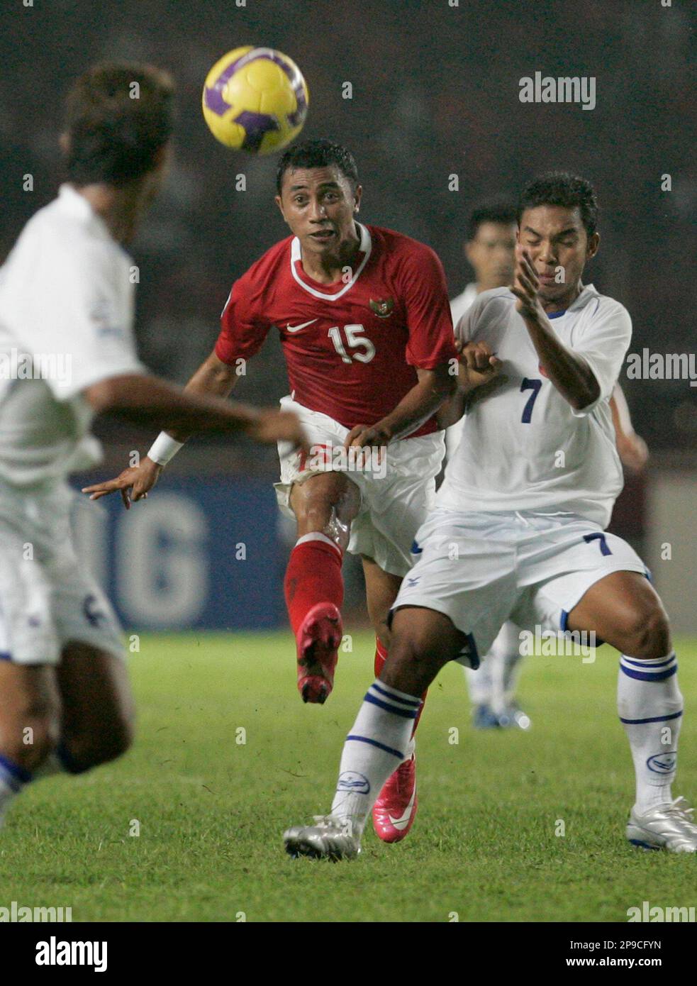 Indonesia's Firman Utina, center, battles for the ball with Myanmar's ...
