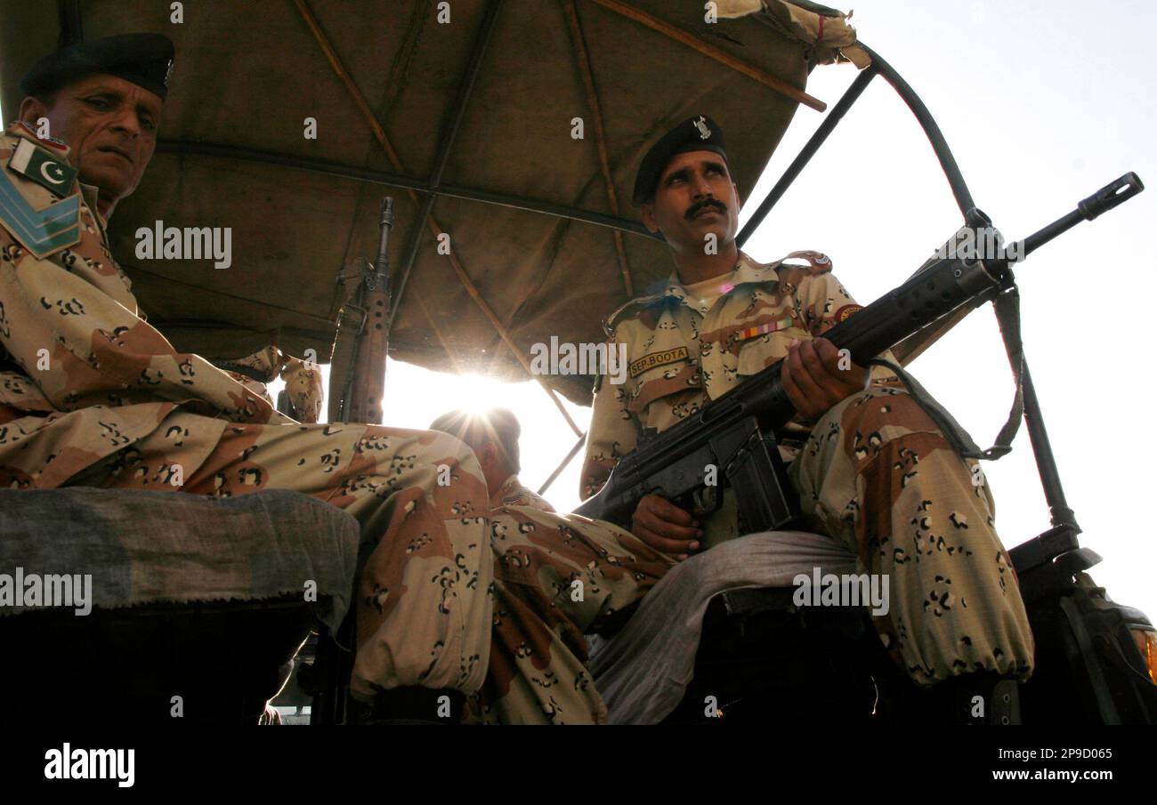 Pakistani paramilitary troops keep guard at a road to ensure security ...