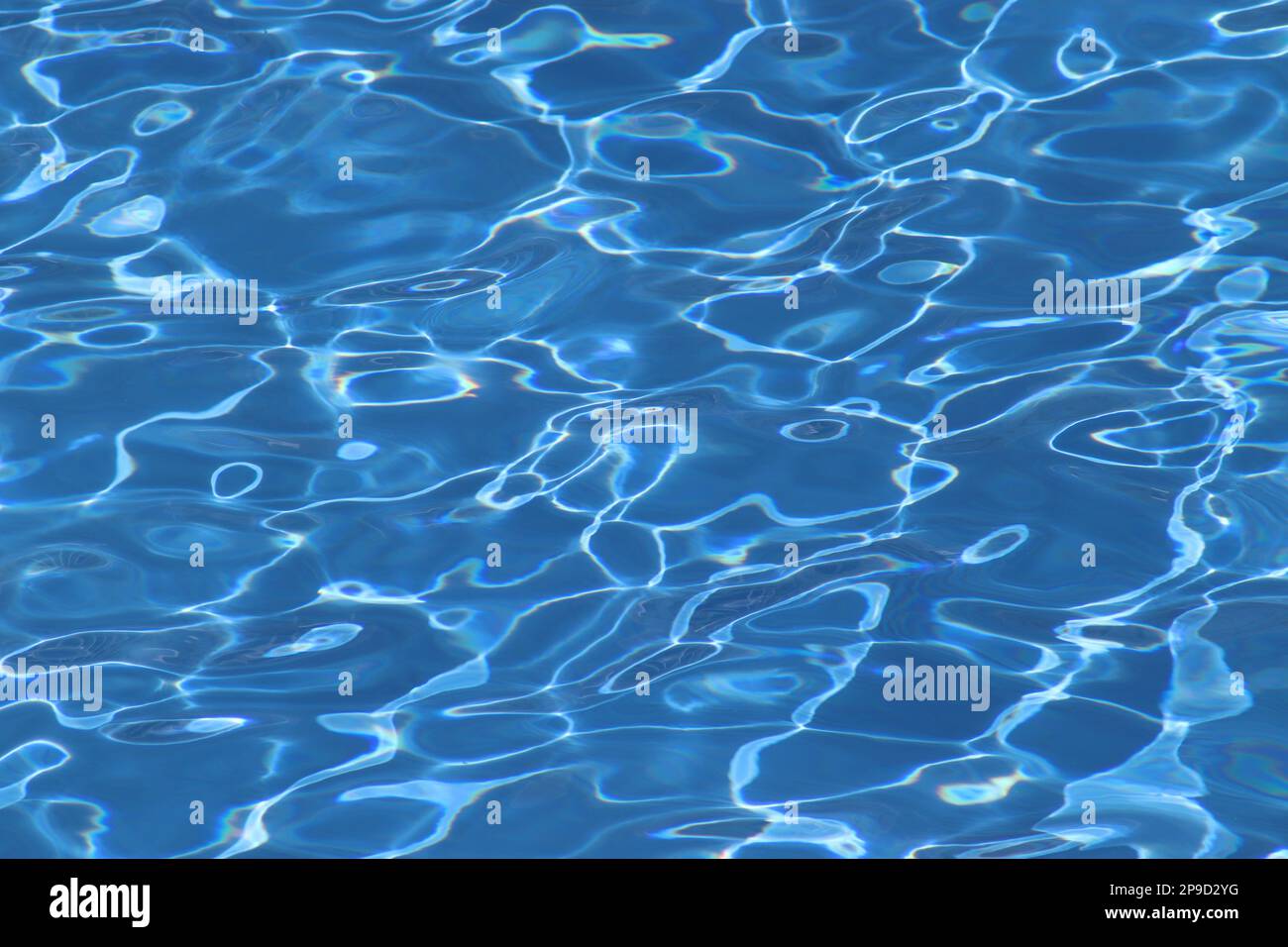 Sunlight and reflections dancing on the rippled surface of the open air ...