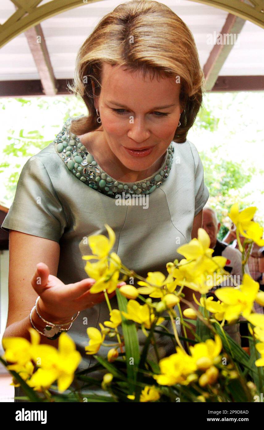 Princess Mathilde of Belgium, left, admires a pot of orchids, the ...