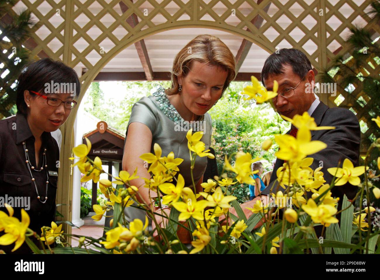 Princess Mathilde of Belgium, center, admires a pot of orchids, the ...
