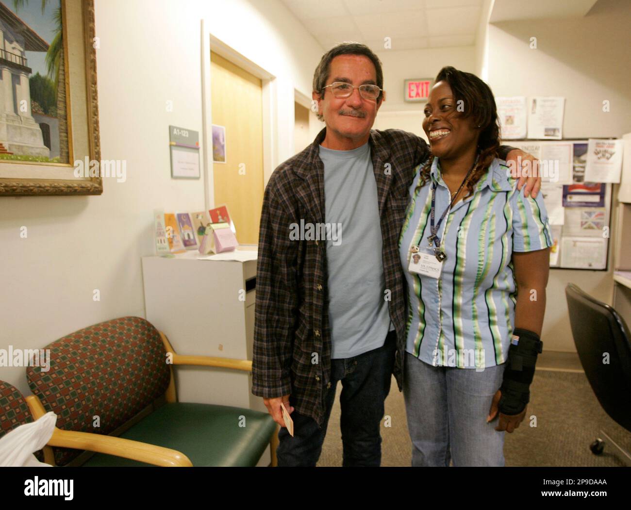 June Moss, right, gets a hug from veteran Gary Newell, left, who frequently stops by to visit ...